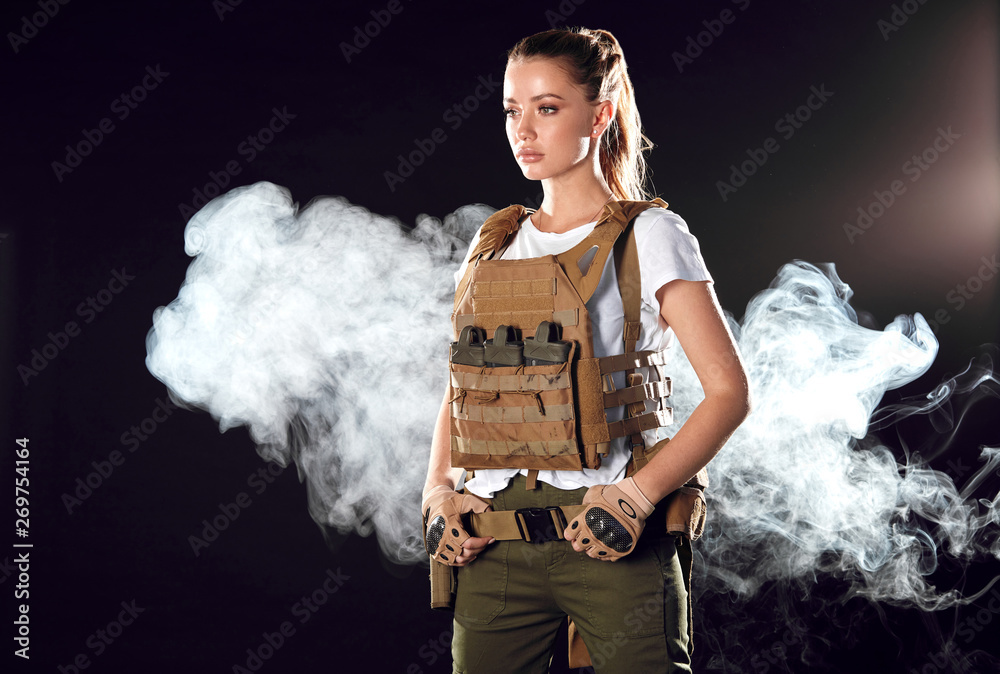 Brave amazing army girl wearing military plate carrier upon white t ...