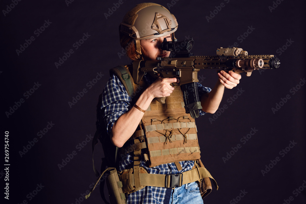 Female civil in tactical uniform with rifle. Shot in studio on black ...