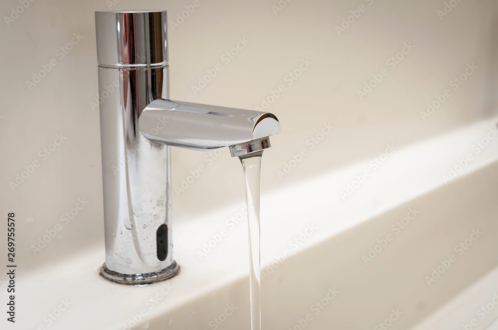 Steel modern design steel faucet with a running water flow. Wasting ...