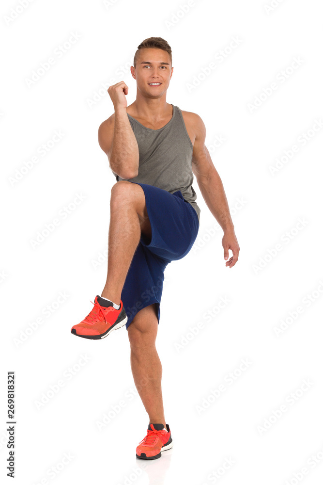 Young Man Standing On One leg And Touching With His Elbow To The Knee ...