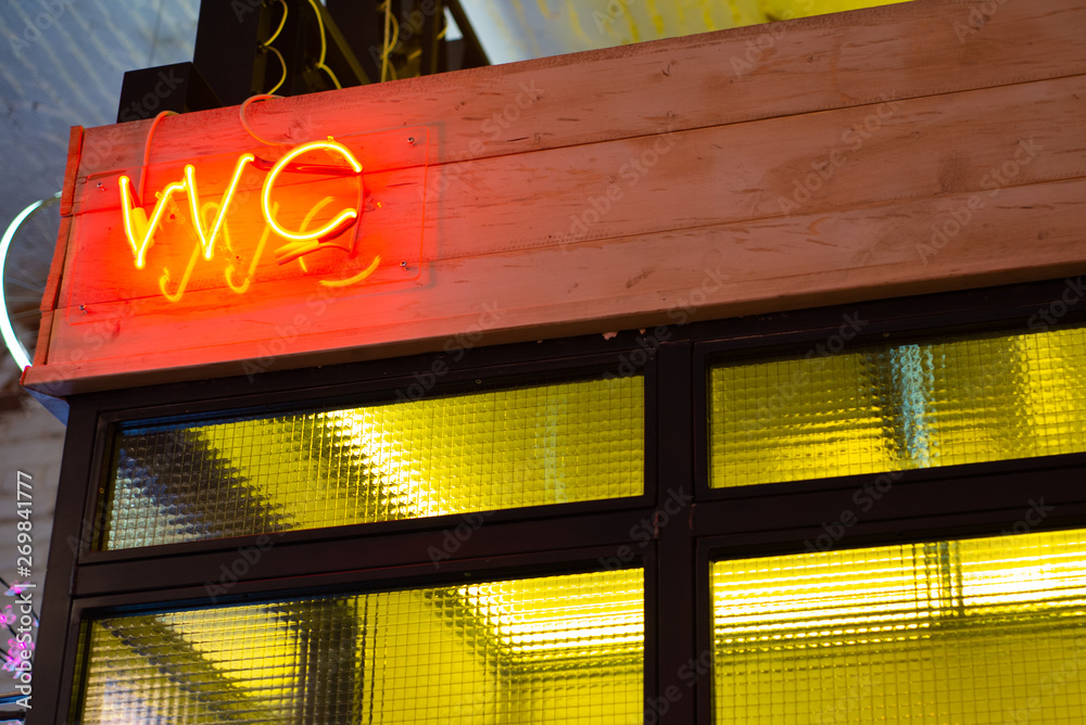 Glowing neon WC sign for public restrooms sign. Shining letters showing ...