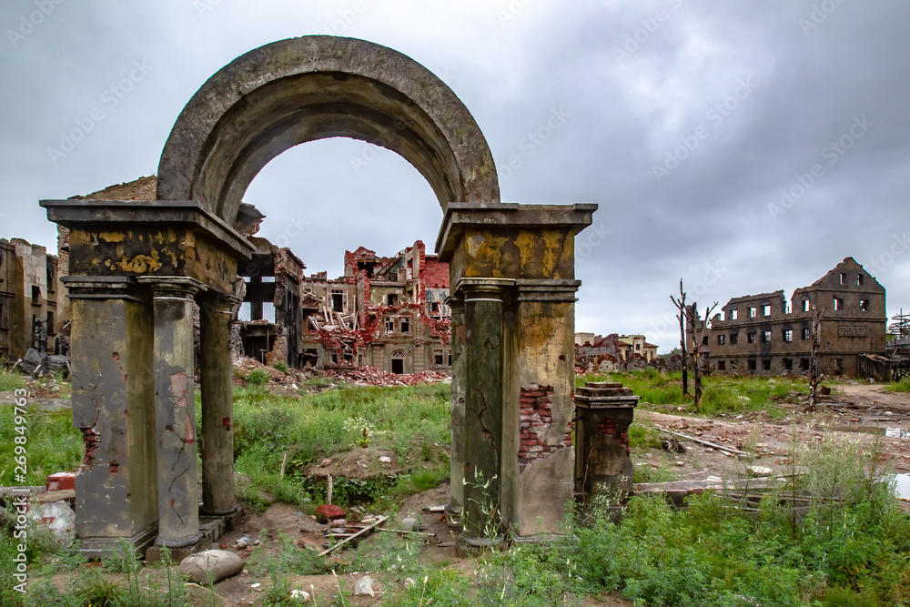 Destroyed town. The remains of the ruined arch. Shambles of houses ...