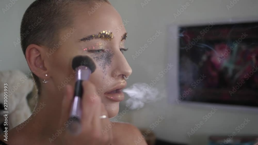 Woman putting on makeup while smoking. Lady exhaling cigarette smoke ...