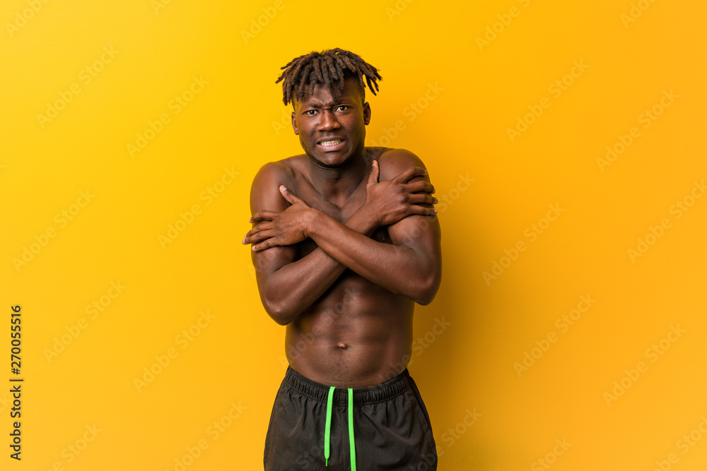 Young black man shirtless wearing swimsuit going cold due to low ...