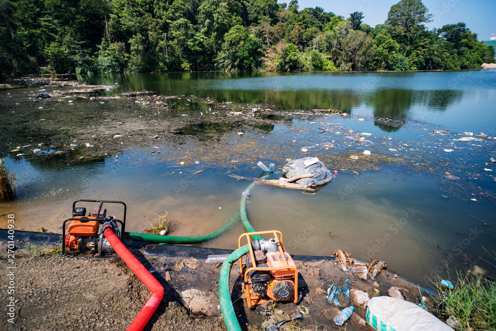 City dump in the pond in Park. Garbage lies in the water on one of the ...
