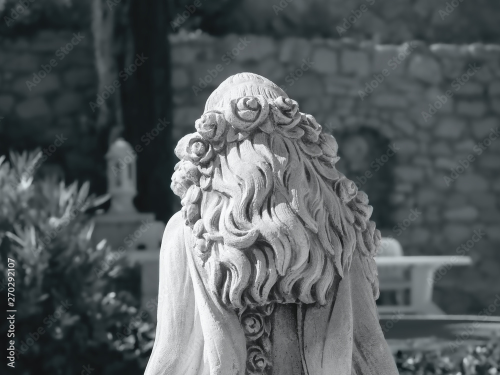 upper back view of a white stone female statue, curly long hair Stock ...