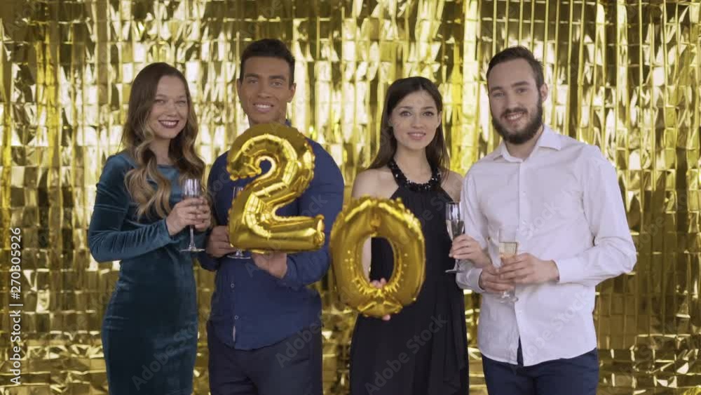 The number 20 of foil. 4 happy cheerful people at a party with balloons ...