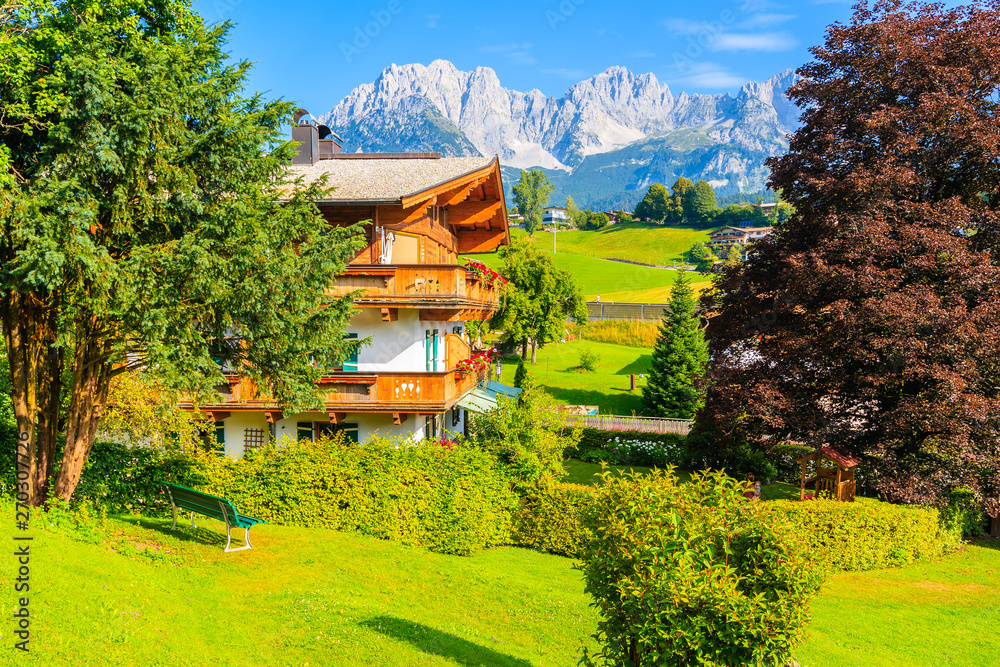 Traditional alpine house in village of Going am Wilden Kaiser with Alps ...