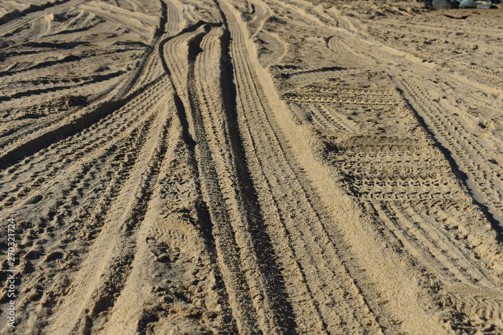 Four wheel drive tyre marks in sand with vanishing point background ...