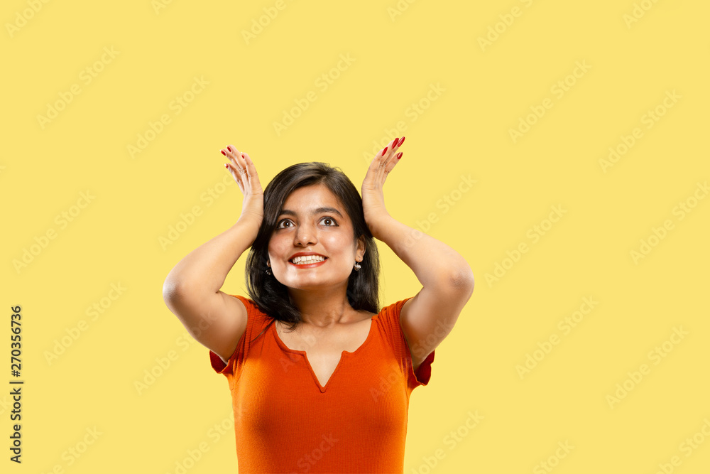 Beautiful female half-length portrait isolated on yellow studio ...