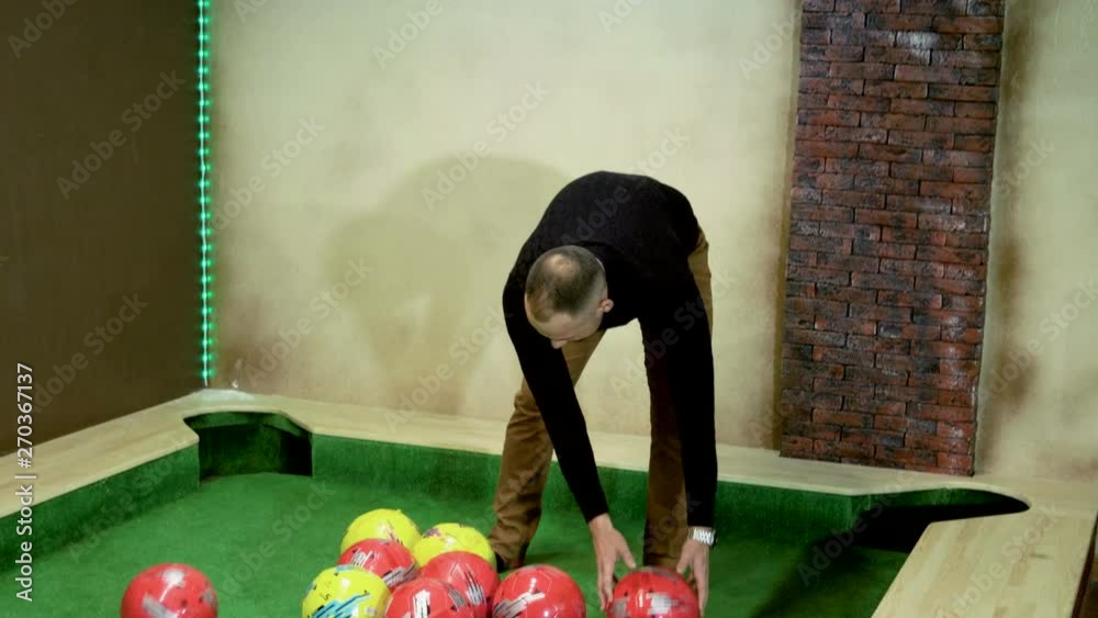 Two men playing billiards, hitting balls with legs, kicking it into ...