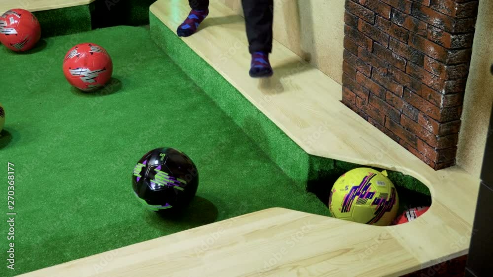 Two men playing billiards, hitting balls with legs, kicking it into ...