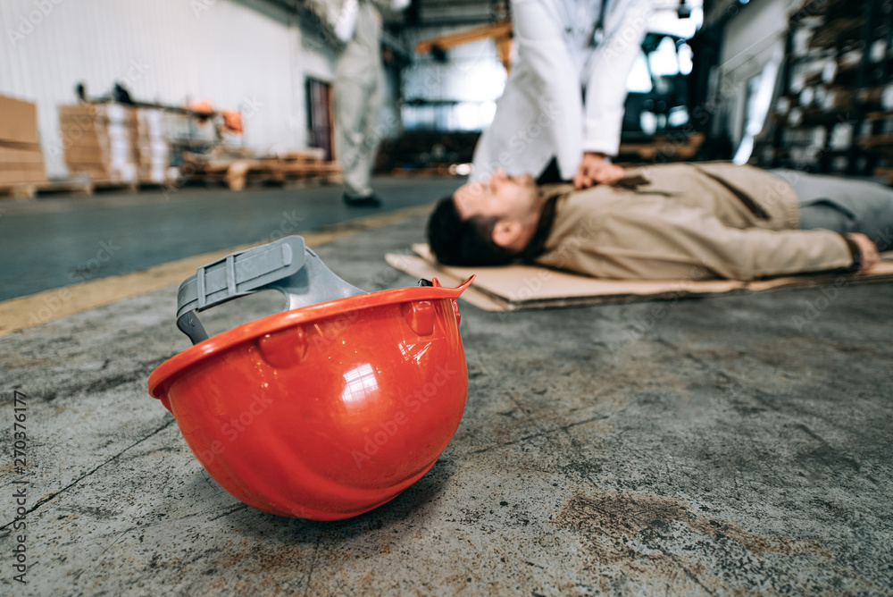 Unconscious worker lying on a warehouse floor. Stock Photo | Adobe Stock