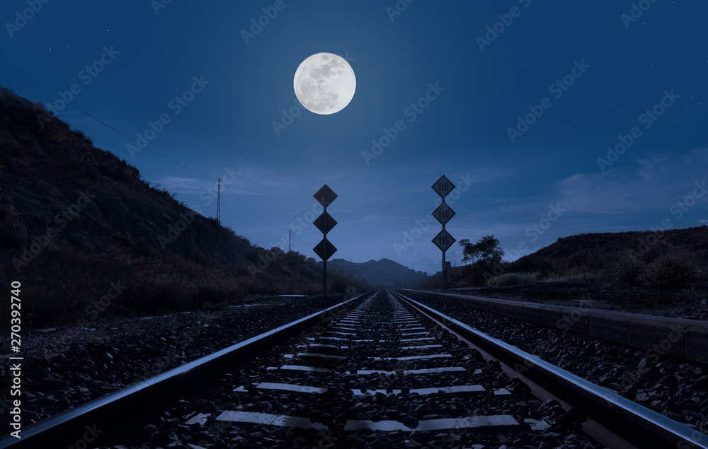 At night, the railway tracks lead to the middle of the horizon where ...