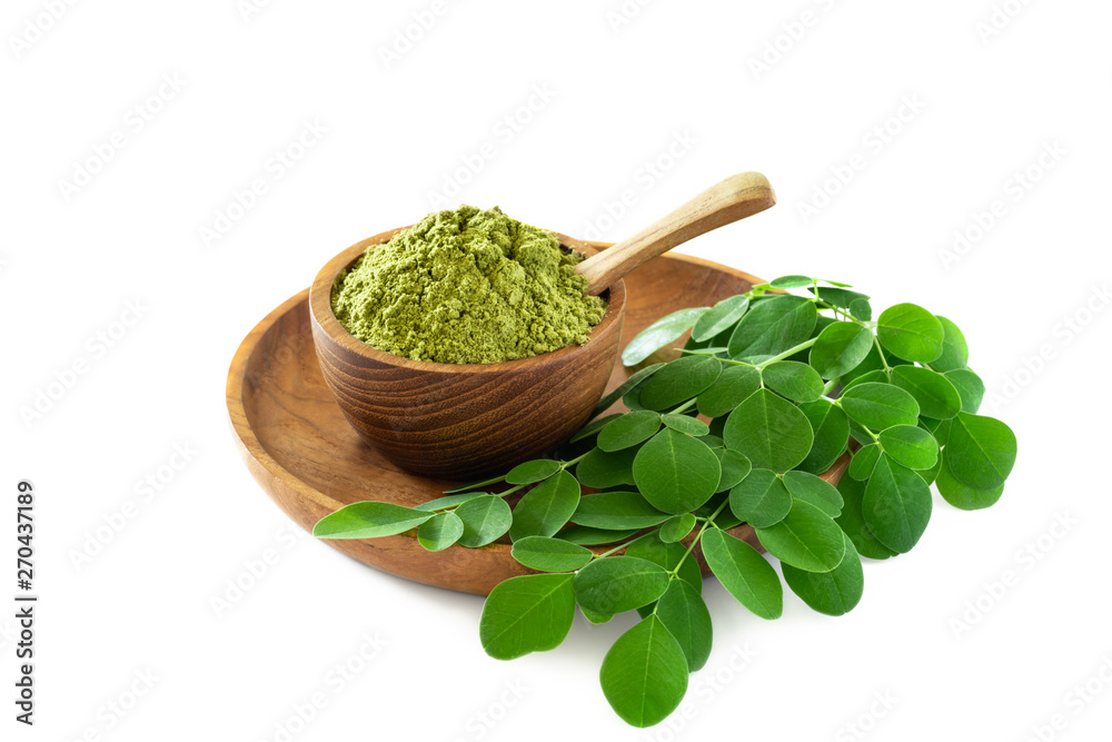 Moringa powder in wooden bowl with original fresh Moringa leaves ...
