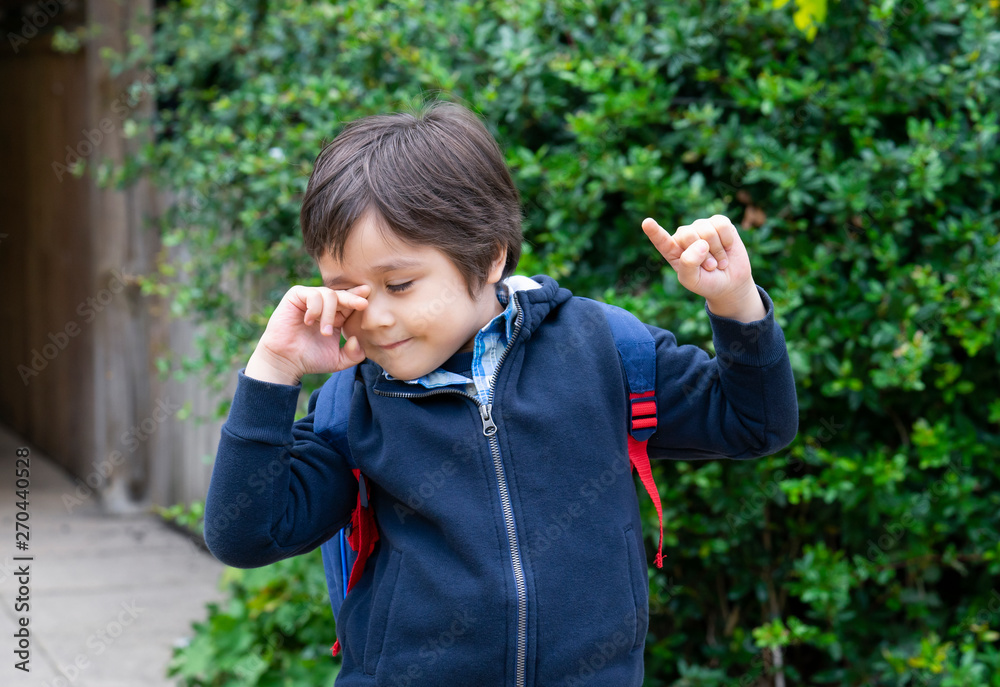 Cute boy smiling and closing eyes while walking and having fun in the ...