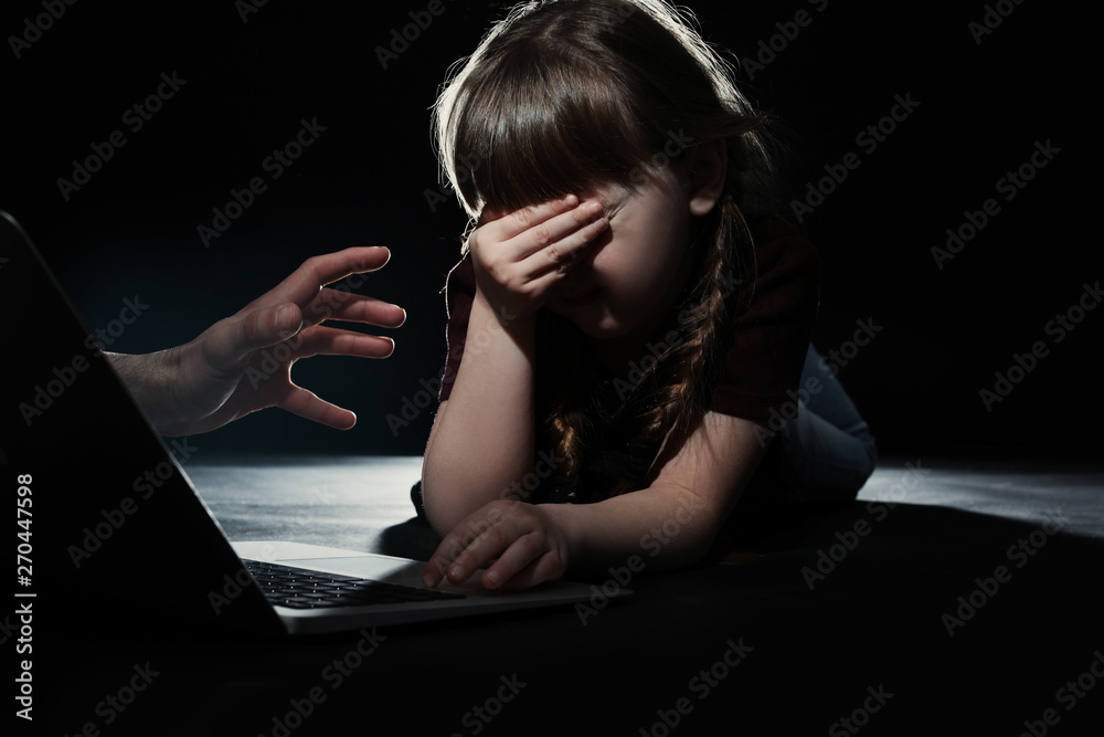 Stranger reaching frightened little child with laptop on dark ...