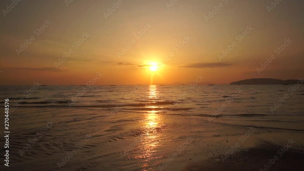 Beautiful bright orange sunset over the Indian Ocean. The soft foamy ...