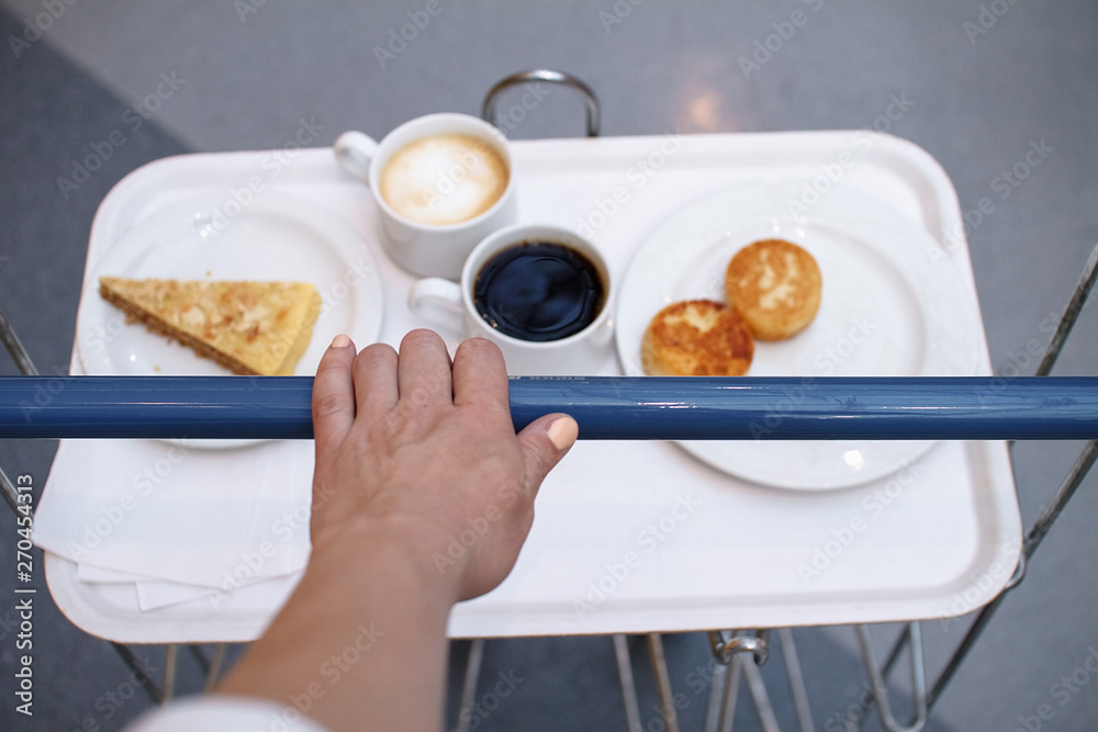Fast food concept. In the frame hand carries a cart, a tray of coffee ...