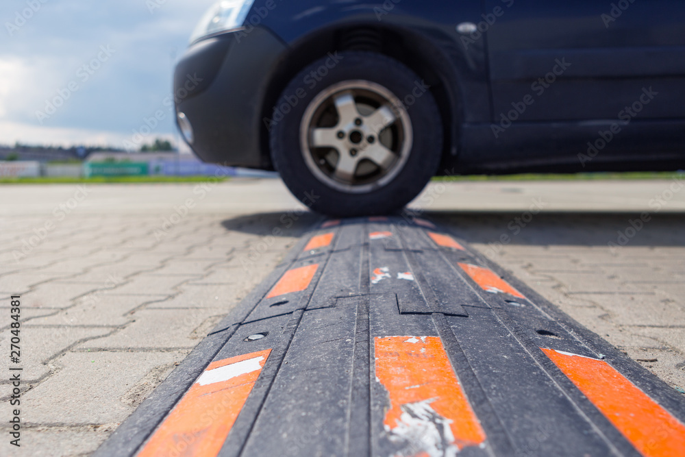 Foto de Car moves a speed bump on a city street. do Stock | Adobe Stock