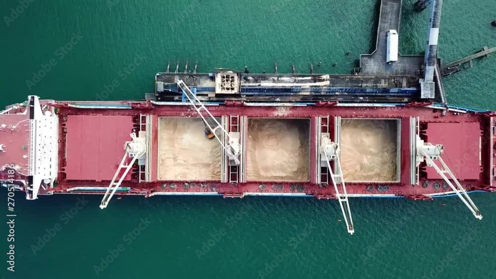 Sugar container cargo ship, top down aerial pan as cranes and diggers ...