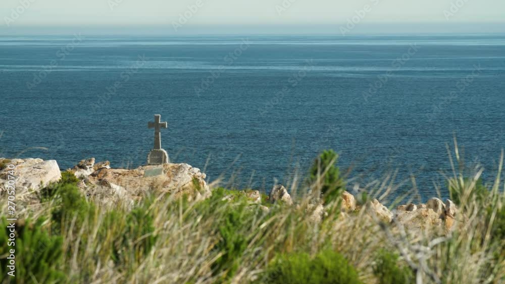 Coastal view of gravestone overlooking blue ocean with green grass ...
