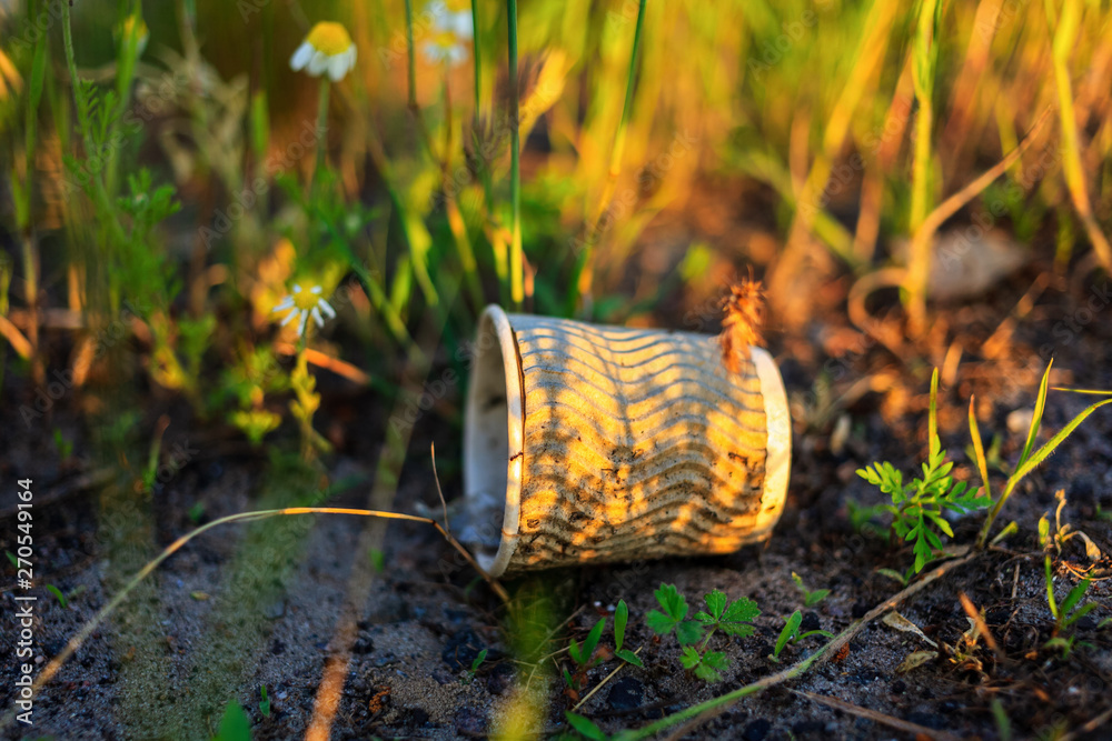 Used Coffee mug in the forest as symbol for pollution. Plastic ...