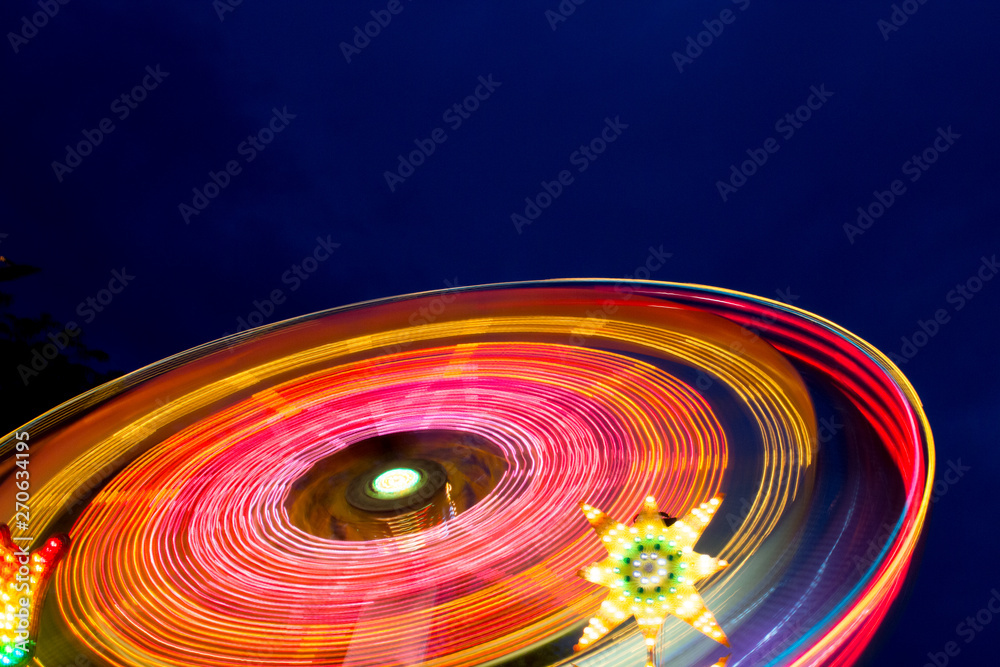 Horizontal photo of funfair carousel in movement taken at night ...