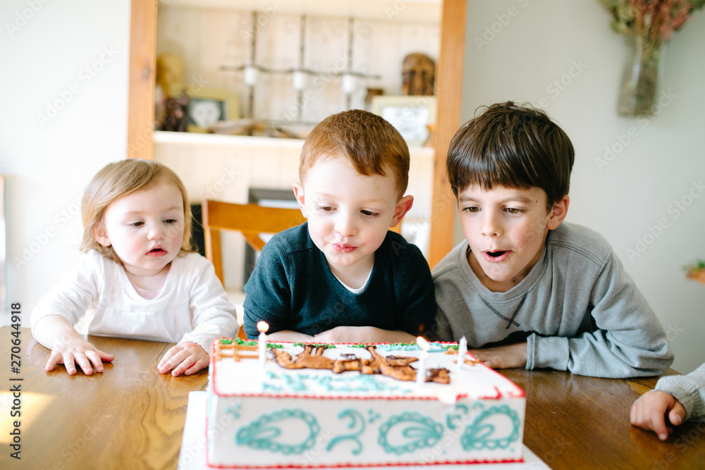 kids blowing out candles on cake Stock Photo | Adobe Stock