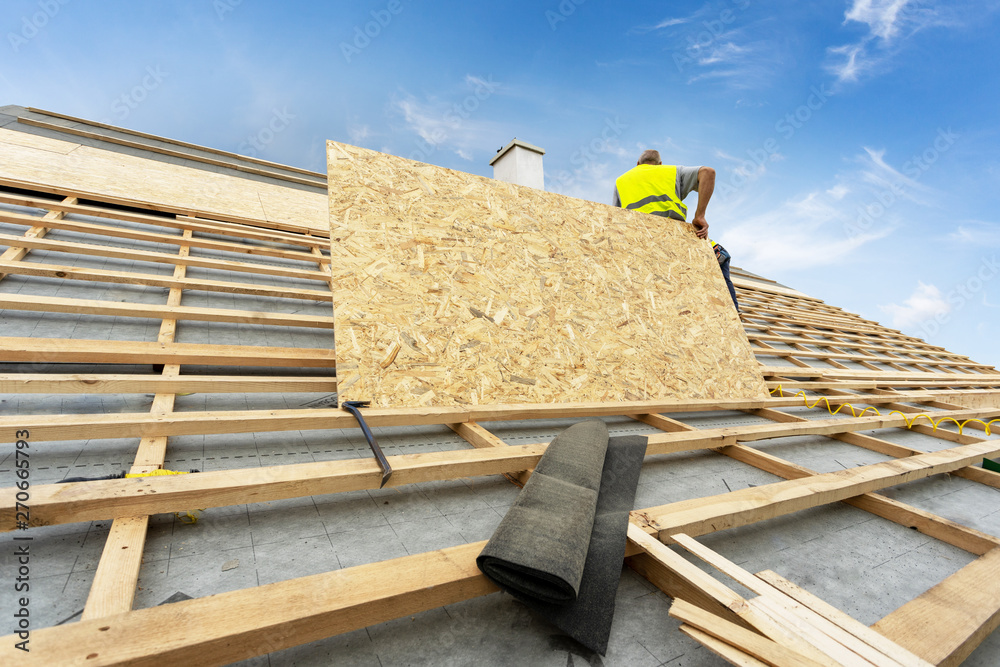 Building construction process of new wooden roof on wood frame house ...