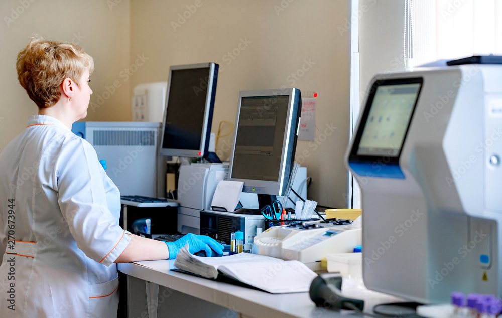 Laboratory technician woman checking the analysis of blood, working on ...