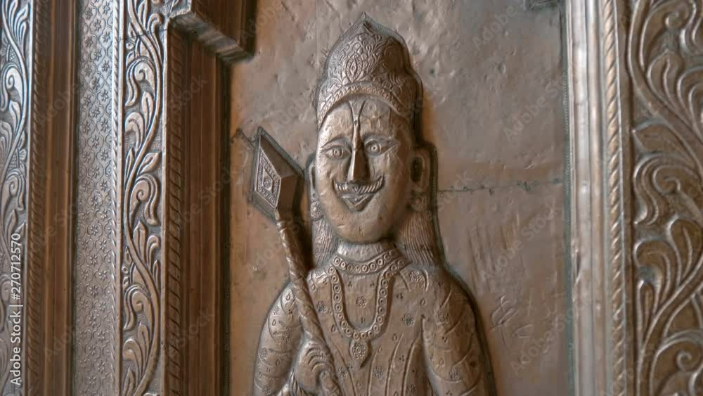 The entrance door to the temple is decorated with beautiful metal ...