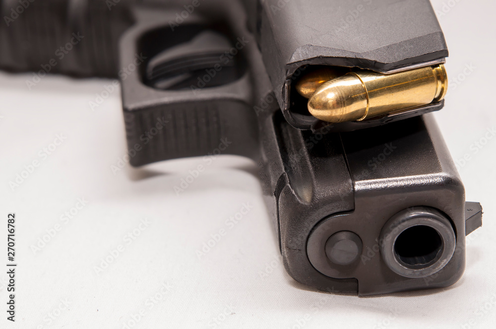 A black 9mm pistol with a pistol magazine loaded with full metal jacket ...