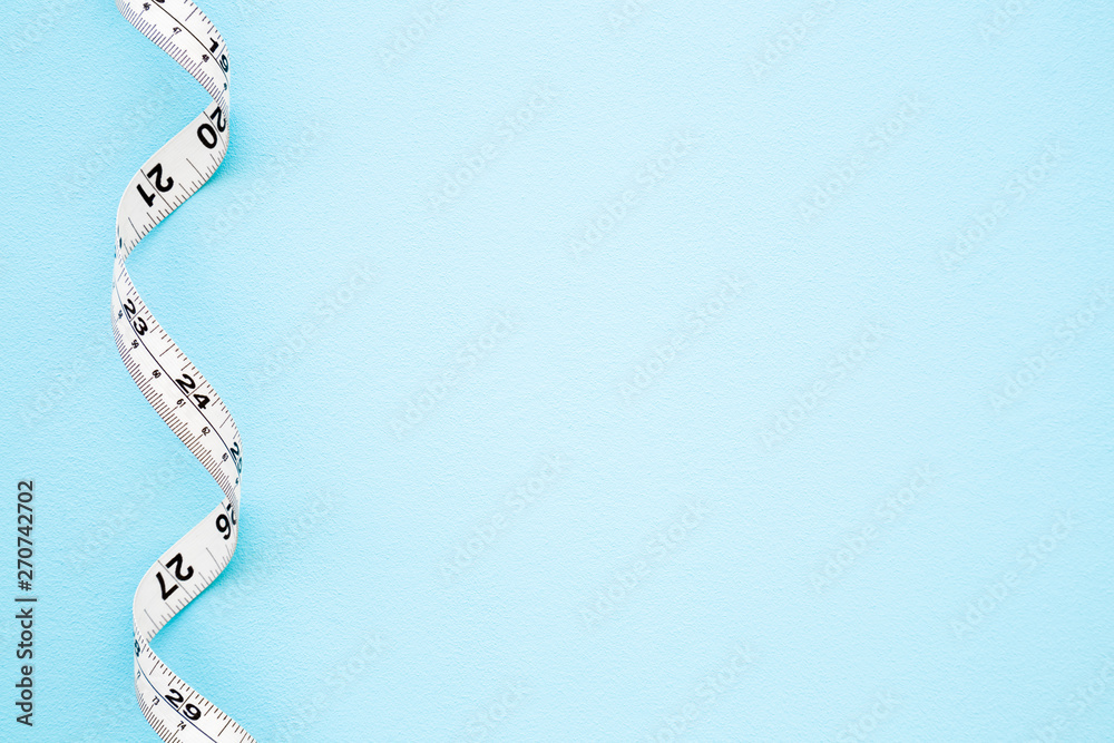 Measure tape on the pastel blue background. Mock up for body slimming ...