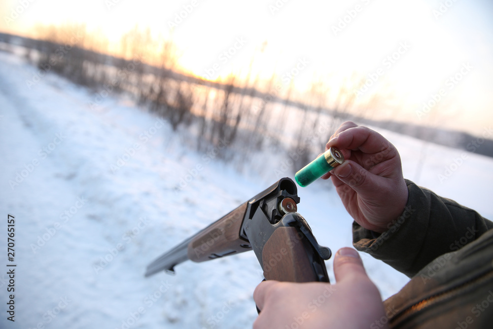 Hunter's hand charges the hunting cartridge in the gun. Reloading ...