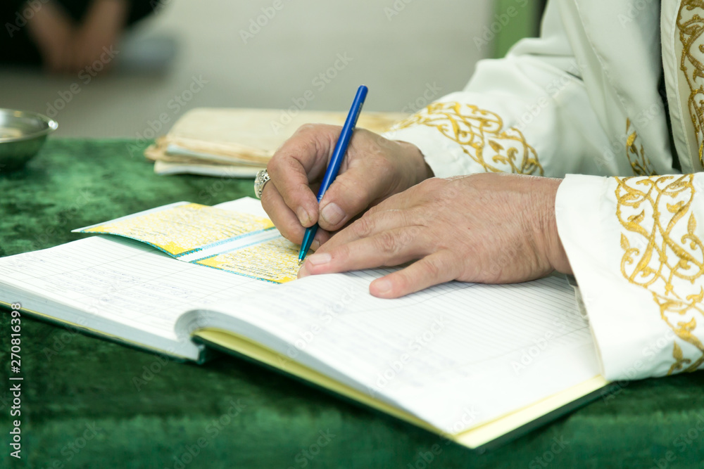 Mula sveschenosluchitel writes the names of the bride and groom. The ...