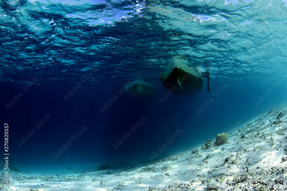The bottom of the fishing boat view from under the water. Blue ...