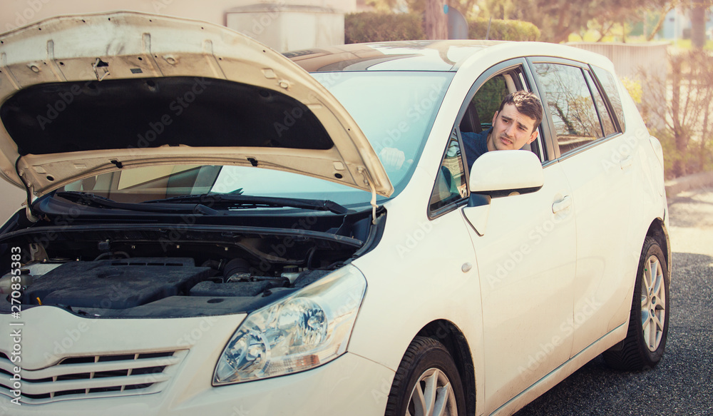 Confused and stressed driver with head out of his car window looking at ...