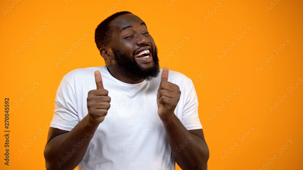 Happy African-American man rejoicing and showing thumbs-up, best life ...