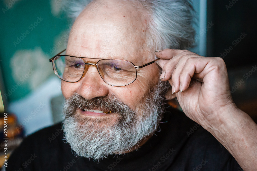Closeup portrait of Caucasian old man wearing glasses and smiling, with ...
