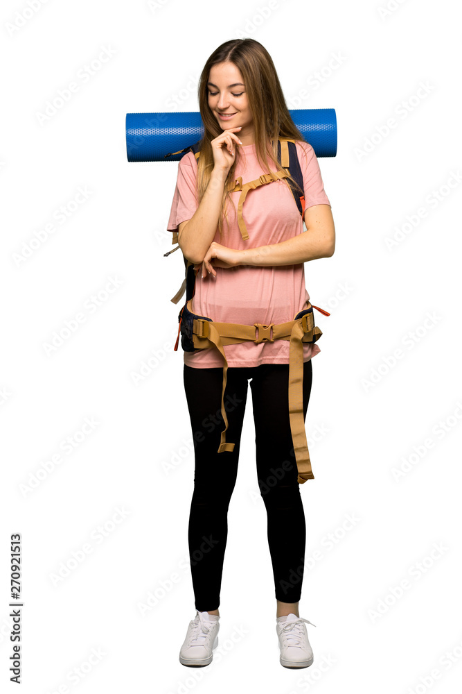 Full body Young backpacker woman looking down with the hand on the chin ...