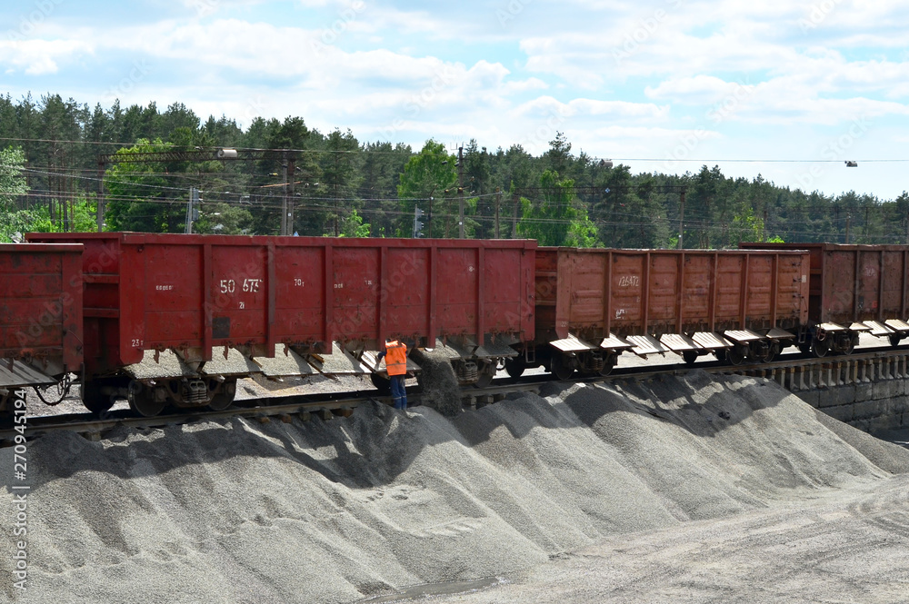 Unloading of crushed stone from railway car. Unloading bulk cargo from ...