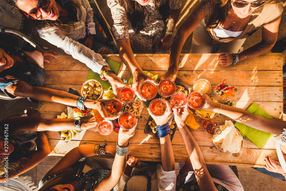 Above view group of friends people enjoy food and drinks toasting and ...