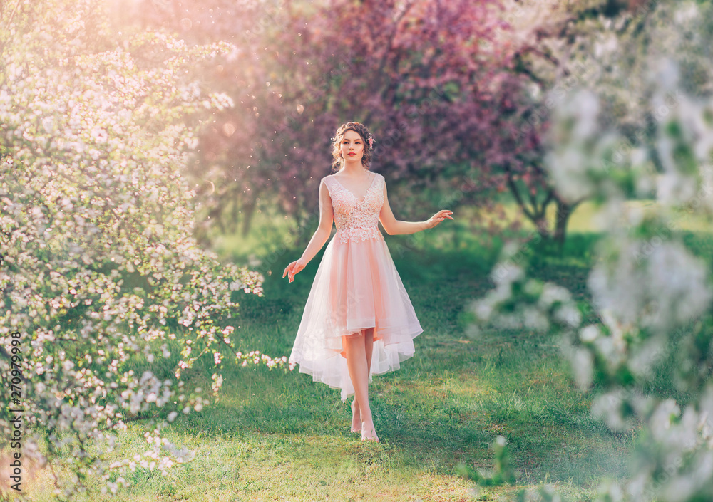 mysterious lady with dark gathered hair in a light delicate peach dress ...