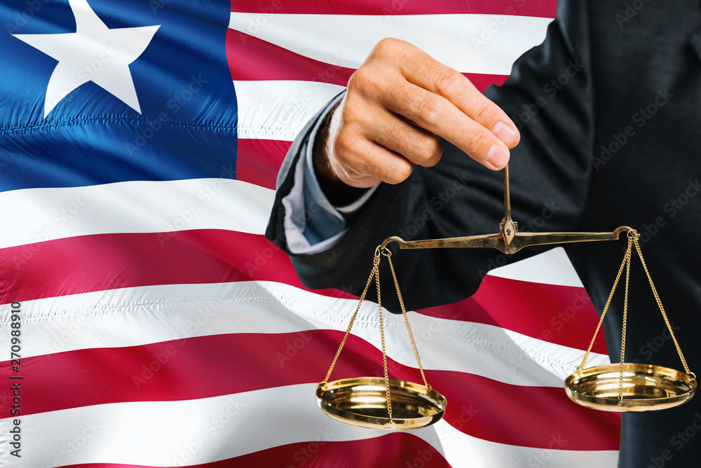 Liberian Judge is holding golden scales of justice with Liberia waving ...