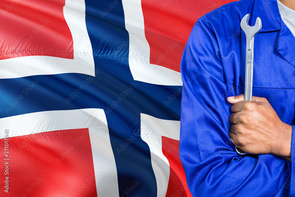 Norwegian Mechanic in blue uniform is holding wrench against waving ...