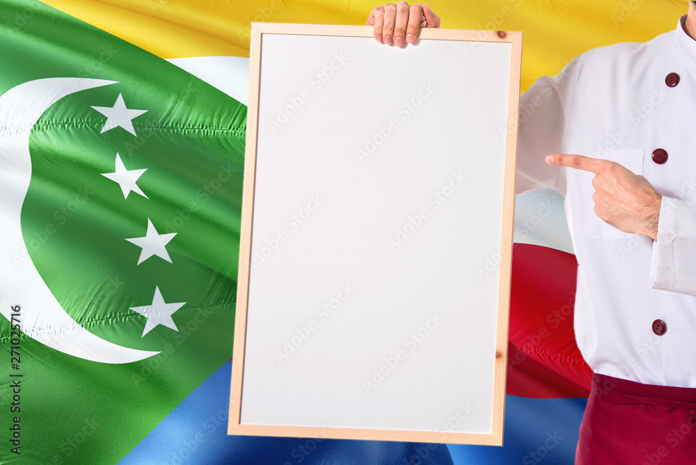 Comoran Chef holding blank whiteboard menu on Comoros flag background ...