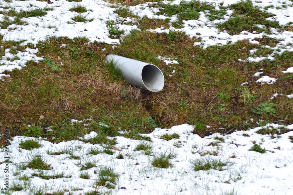 Closeup photograph of a drain pipe of a dry retention basin. Grass ...