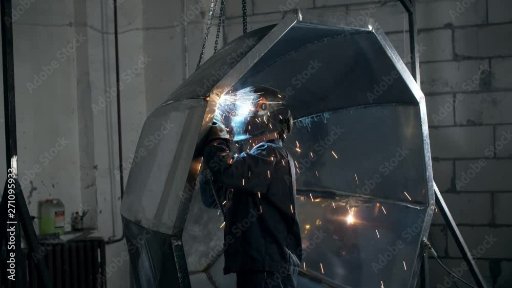 Vidéo Stock Welder worker in overalls and in a welding mask welds ...