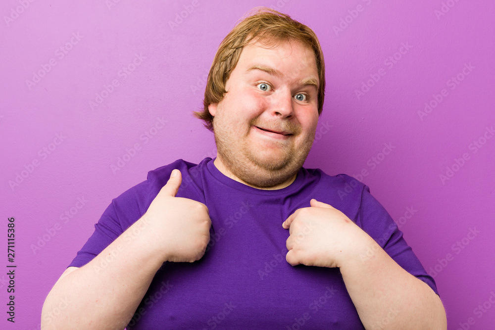 Young authentic redhead fat man surprised pointing with finger, smiling ...
